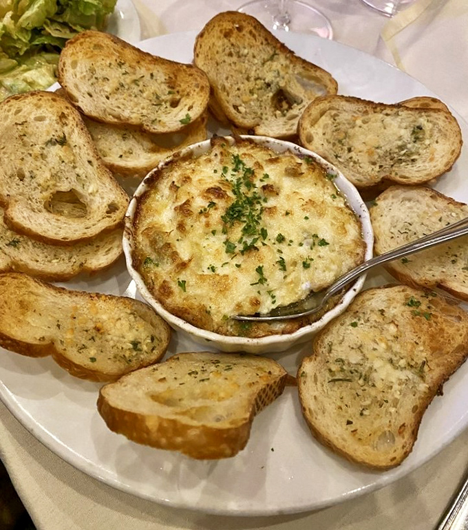 Bubbling hot crab dip surrounded by garlic toast—the appetizer equivalent of a warm hug. Sharing optional but not recommended.