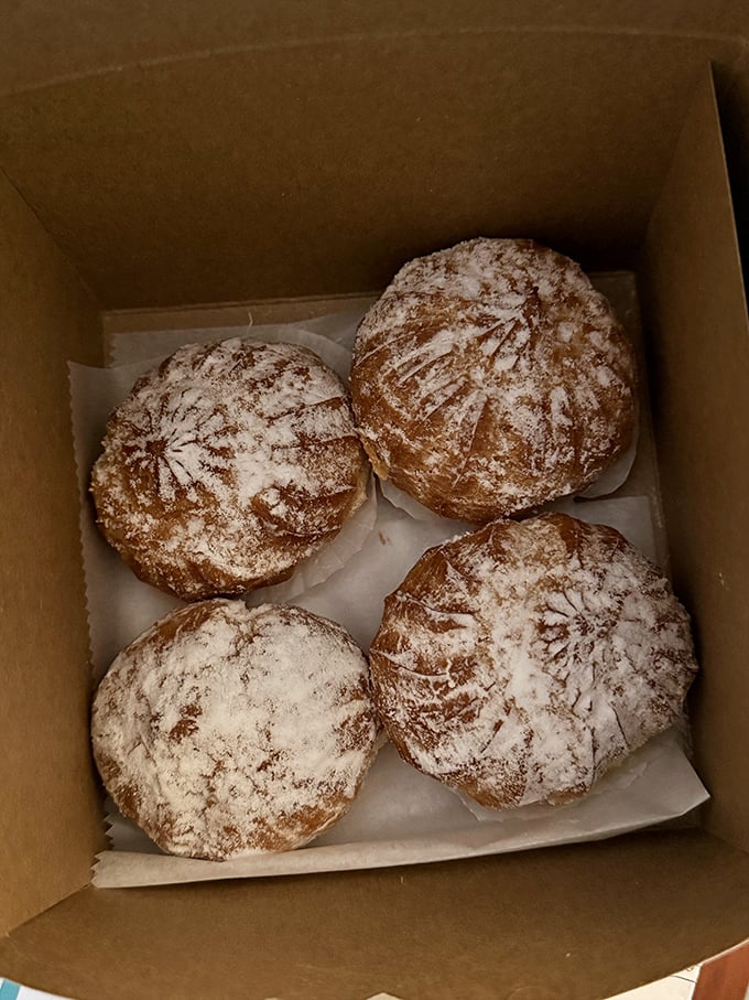 Powdered sugar-dusted cream puffs that look like they fell from a cloud. One bite and you'll understand why people line up for these.