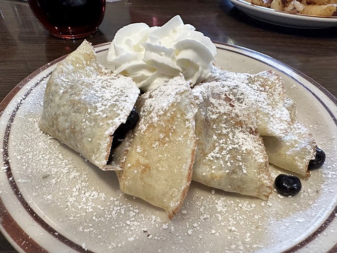 Delicate crepes dusted with powdered sugar and crowned with whipped cream transform breakfast into a sweet celebration.