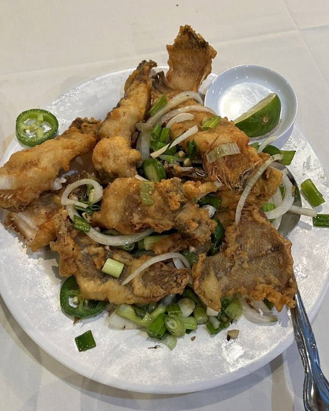 Crispy fried fish that shatters like glass when touched, adorned with a confetti of jalape&ntilde;os, onions, and herbs.