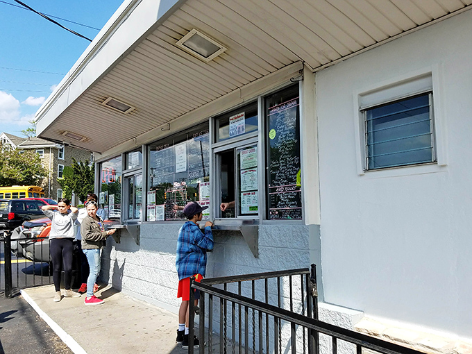 The universal language of ice cream brings strangers together at this window, where patience is always rewarded with cold, creamy bliss.