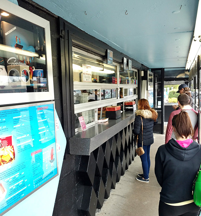 The outdoor ordering window keeps the authentic drive-in experience alive, where patience is rewarded with packages of pure Chicago culinary tradition. 