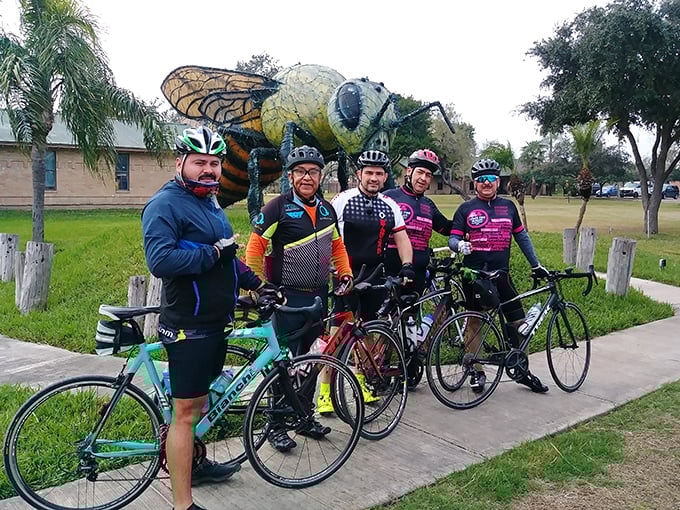 Cyclists make a pit stop at the famous landmark. Nothing says "great ride" like a photo op with a ten-foot insect.