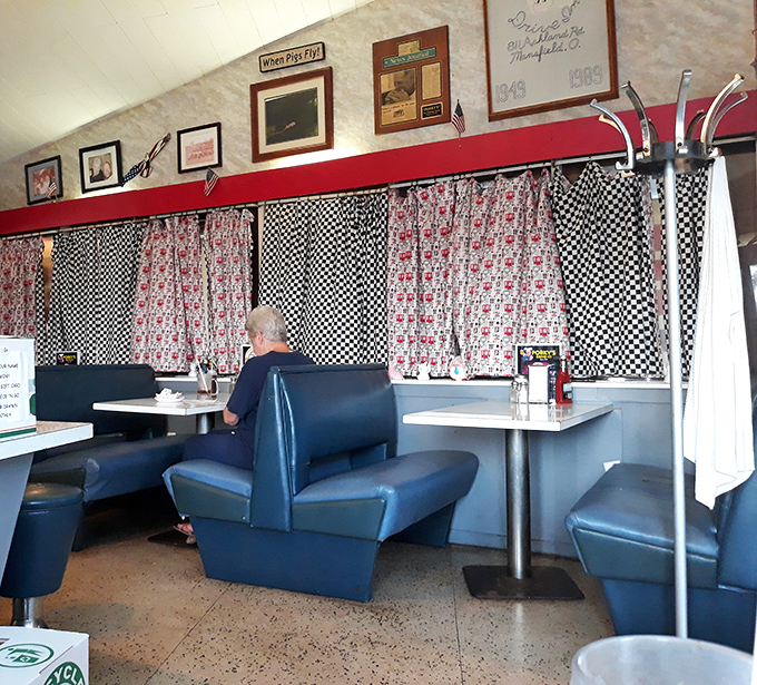 Blue vinyl booths and checkered curtains create the perfect backdrop for conversations that flow as easily as the coffee refills.