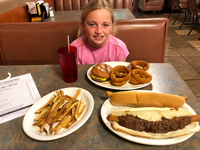 A young diner contemplates the serious business of onion rings, burgers, and fries&mdash;learning early that life's greatest pleasures often come on plain white plates.