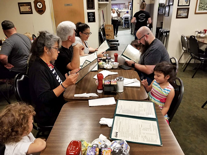 Multi-generational families poring over menus—the universal sign that you've found a place where food traditions are passed down like heirlooms.