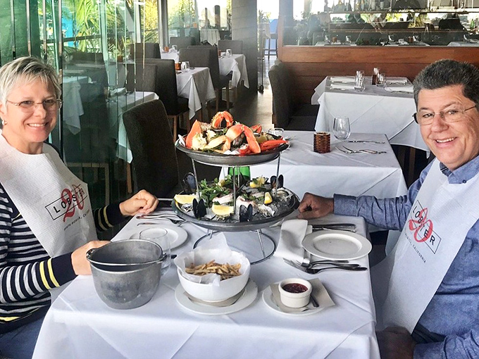 Seafood towers: where dining becomes spectacle. These happy diners are experiencing what might be the ultimate coastal California memory-maker. 