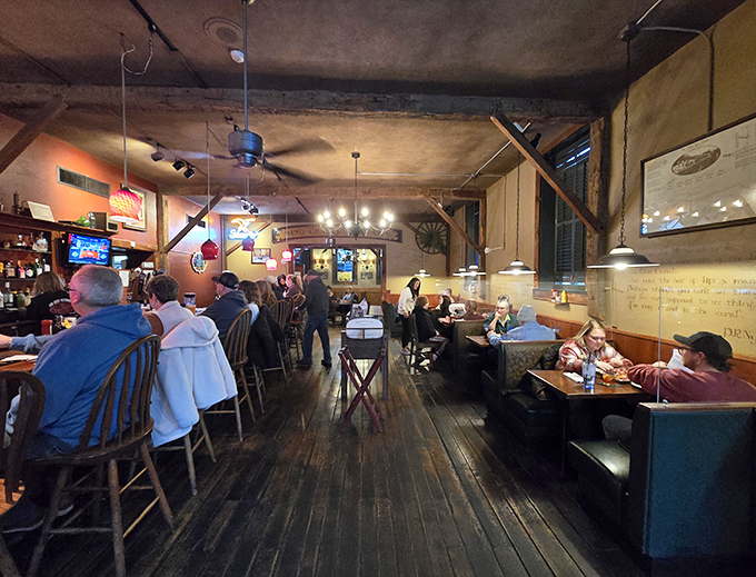 The dining room buzzes with conversation and clinking glasses, where wooden floors and warm lighting turn strangers into neighbors.