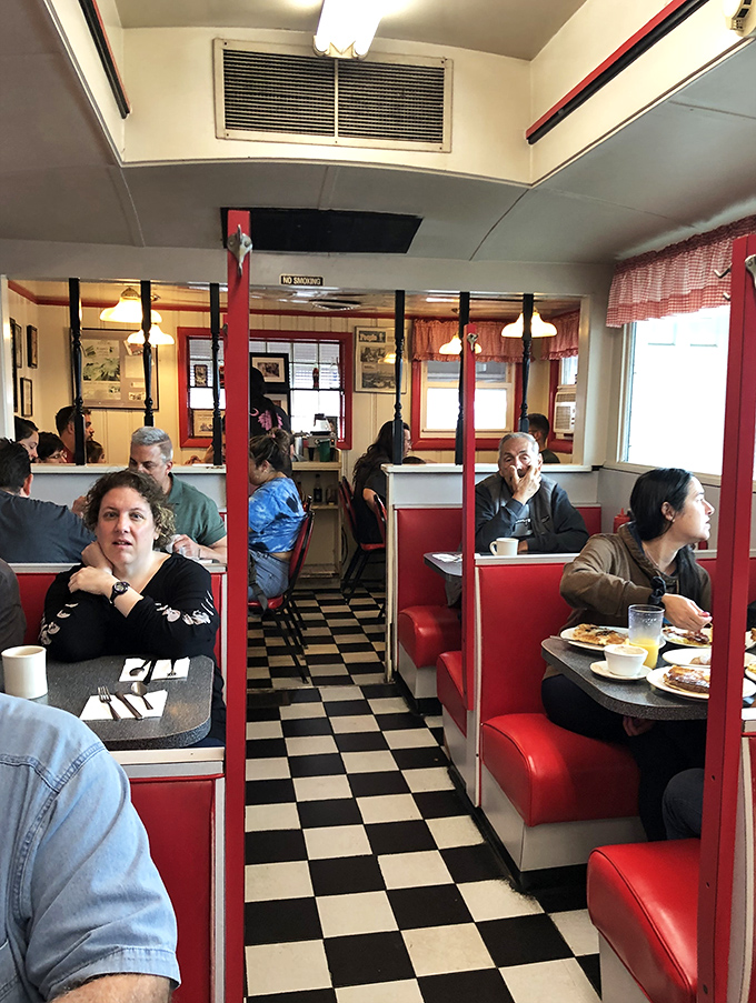 The narrow aisle between booths serves as Middletown's unofficial town square, where regulars and newcomers share space in the democracy of hunger.