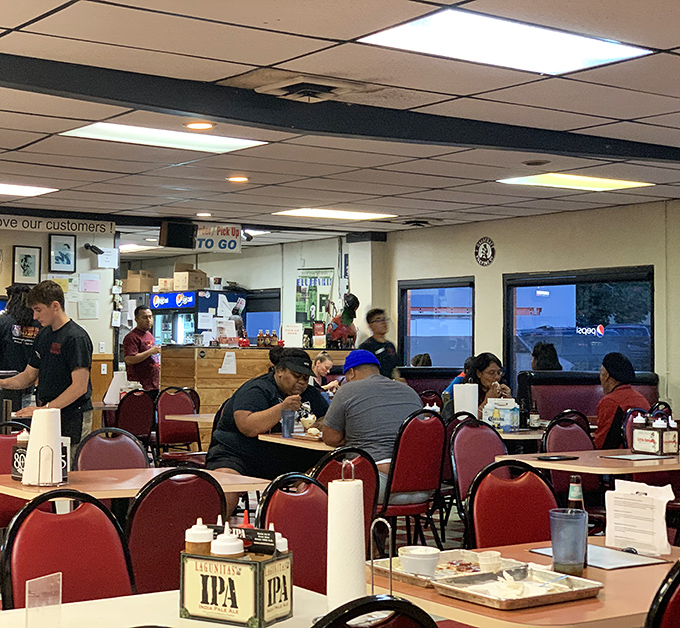 A bustling dining room where strangers become friends, united by the universal language of exceptional barbecue. Notice the IPA caddy&mdash;they know their audience!