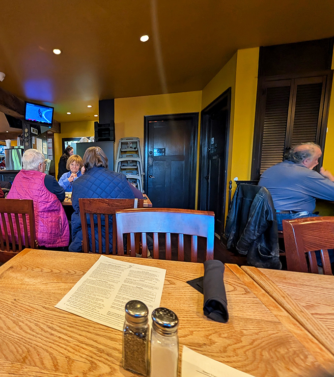 Where locals and visitors become temporary friends over shared plates and pints. The yellow walls and dark wood create that unmistakable pub warmth.