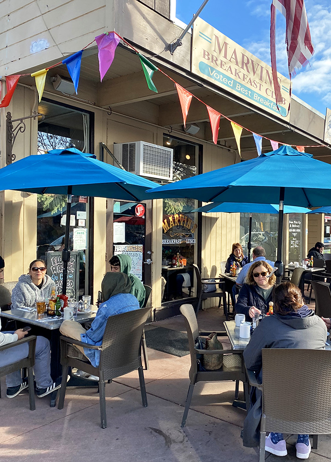 The outdoor seating area, where colorful bunting and blue umbrellas create the perfect setting for enjoying breakfast with a side of California sunshine.
