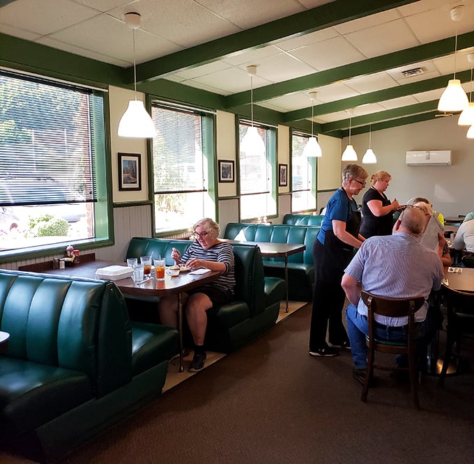 The dining room hums with the satisfied murmurs of locals who've found their happy place. Green booths cradle regulars like old friends.