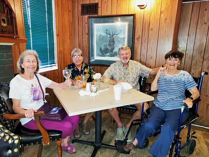 Happy diners gathered around wooden tables prove that good food brings people together better than any social media platform ever could.