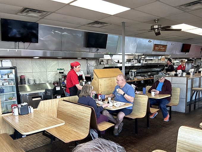 The diner in action&mdash;servers in red, wooden booths, and hungry patrons. That open kitchen concept existed long before trendy restaurants claimed to invent it.