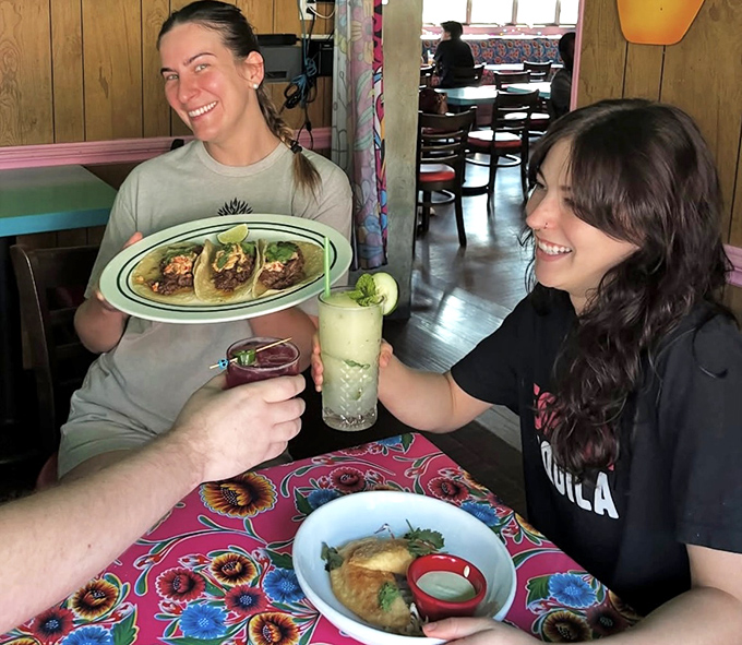 Friends sharing tacos and stories &ndash; the universal language of "you have to try this" needs no translation.