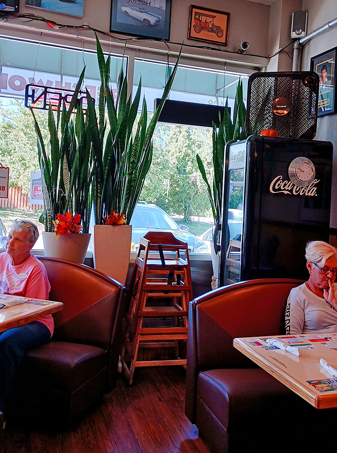 Tall plants frame cozy booths where regulars find their second home, proving diners are as much about community as they are about food.