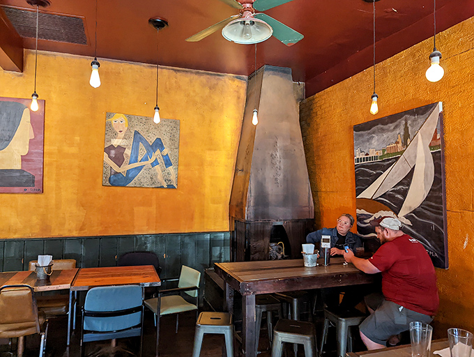 The fireplace corner offers sanctuary for coffee sippers and conversation starters, surrounded by art that says "yes, we're cultured."