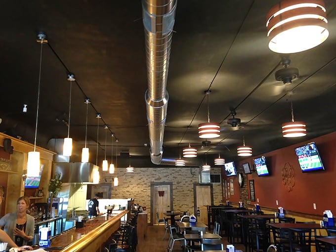 Modern industrial meets hometown warmth in a dining space where pendant lights cast the perfect glow for both game-watching and intimate conversations.