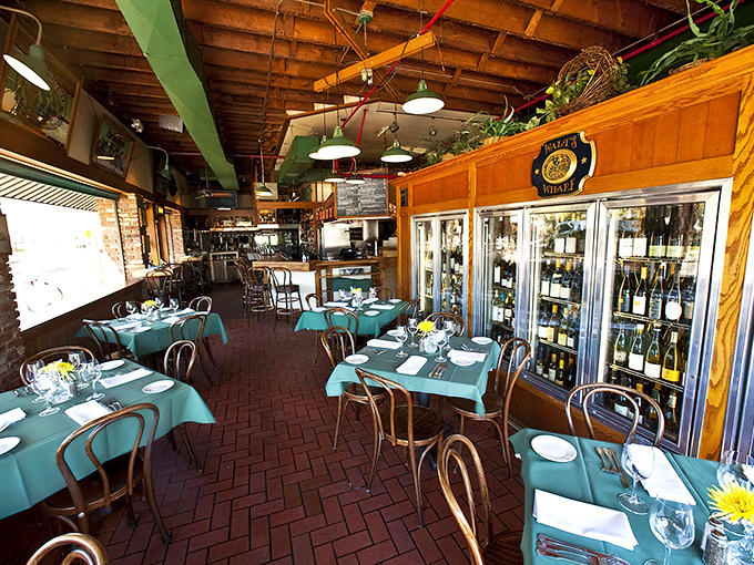 Teal tablecloths pop against brick floors and wooden rafters, while wine displays remind you that great seafood deserves an equally impressive liquid partner.