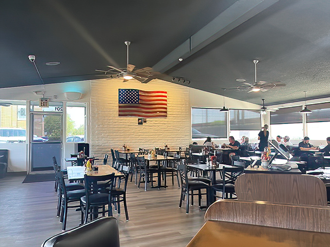 An American flag watches over diners like a patriotic guardian angel, ensuring your breakfast remains as American as the apple pie on the dessert menu.