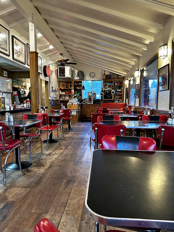 Red chairs pop against wooden floors in a dining room that feels like it's been serving happiness since before you were born.