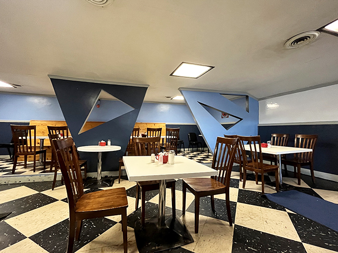 The dining area's geometric blue walls and checkered floor create a retro-space-age vibe that makes even waiting for your food an experience.