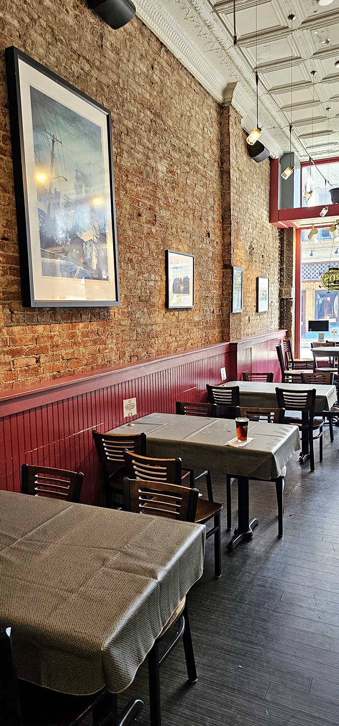 High ceilings, exposed brick, and red wainscoting create that rare atmosphere where both first dates and business lunches feel equally at home.