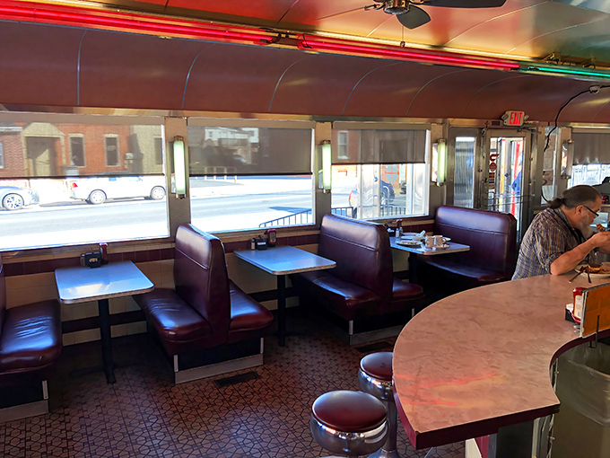 Classic burgundy booths await your sliding entrance. These vinyl thrones have witnessed countless first dates, family gatherings, and solo pancake adventures.