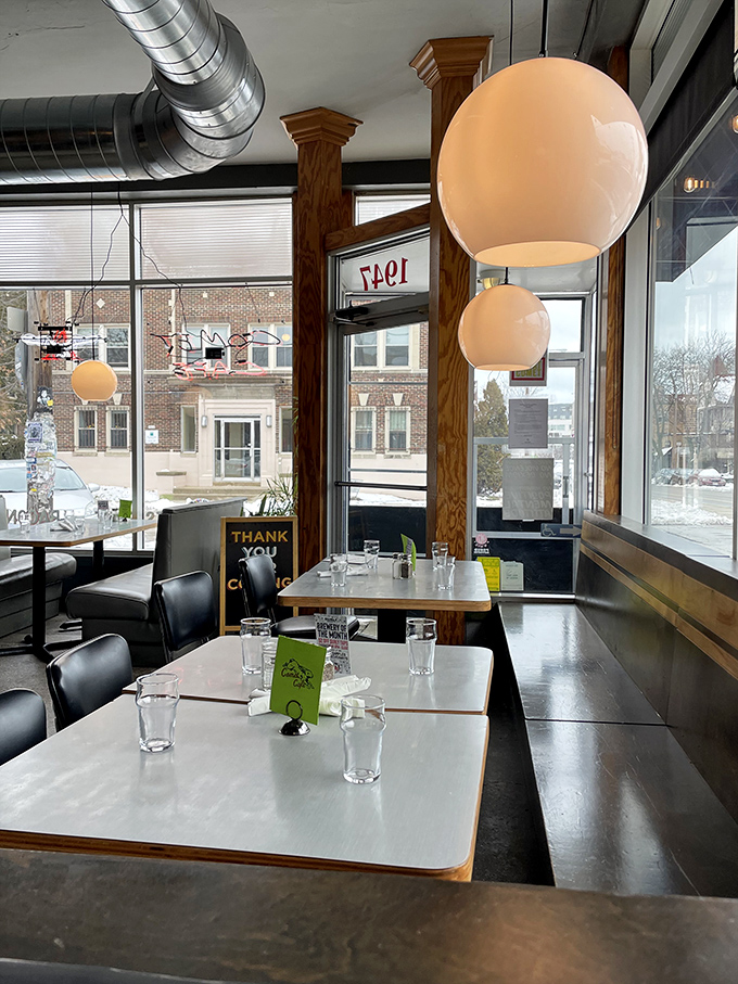 Globe pendant lights cast a warm glow over formica tables. The windows frame Milwaukee's urban landscape like a living postcard.