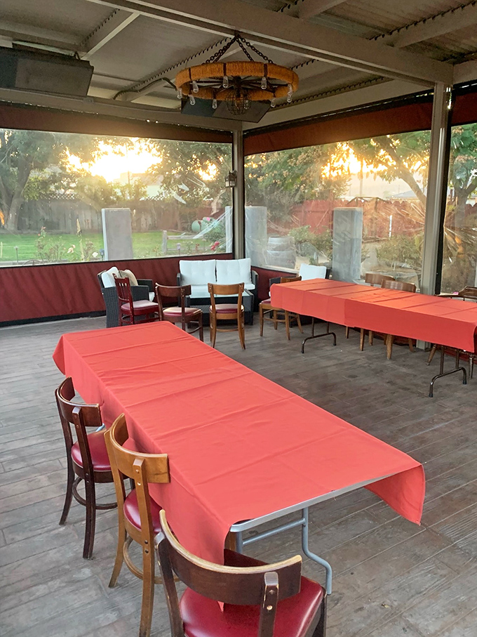 The covered patio offers a sunset view with your supper&mdash;orange tablecloths echo the golden hour glow filtering through the screens.