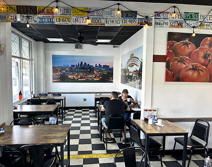 License plates line the ceiling like badges of honor, while Kansas City's skyline watches over diners enjoying their morning ritual.