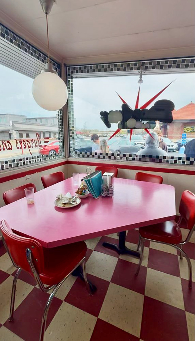 That pink table against the checkerboard floor creates the kind of retro vibe that Instagram filters try desperately to replicate.