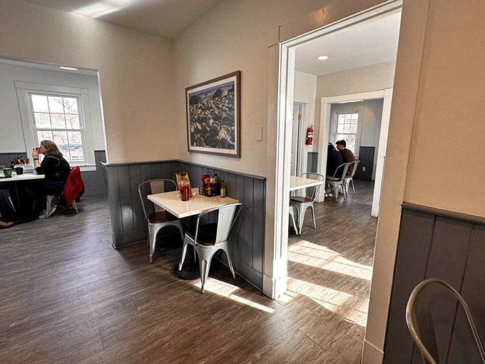 Modern meets maritime in this dining area where sunlight streams through windows, illuminating tables where memories are made between bites of homemade goodness.