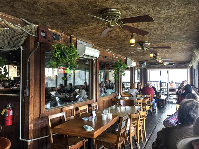 The dining room feels like you're eating in a friend's exceptionally well-placed river cabin. Those ceiling fans have stories to tell.