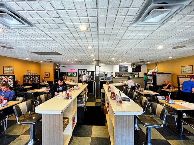 Classic diner counter seating where strangers become temporary breakfast companions. The checkered floor says "we've been here since before trendy was trendy."