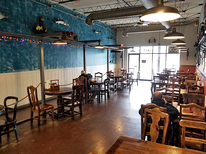 Blue walls evoke ocean waves while string lights add a touch of whimsy. The wooden chairs and tables create a casual, "come as you are" vibe.