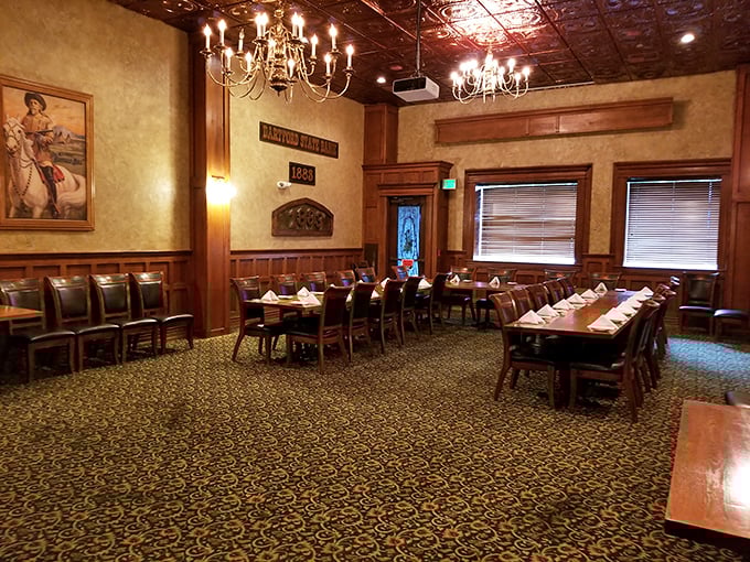 The private dining room waits in quiet elegance, chandeliers casting a warm glow over tables set for memories in the making.
