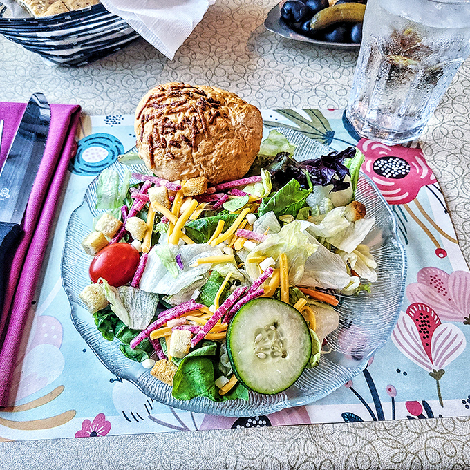 A salad that doesn't apologize for being a salad, with that warm dinner roll standing by like a loyal friend.