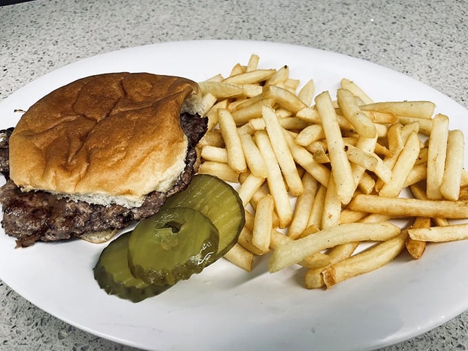Behold the burger in its natural habitat&mdash;simple, honest, and accompanied by fries and pickles that know their supporting roles perfectly.