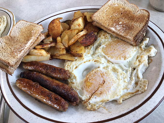 The breakfast trinity: perfectly cooked eggs, sausage links with that satisfying snap, and home fries that could make a potato farmer weep with joy.