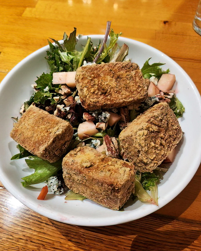 A salad that's having more fun than most entrees. These crispy cubes of what appear to be tofu dance with greens and nuts in perfect harmony.