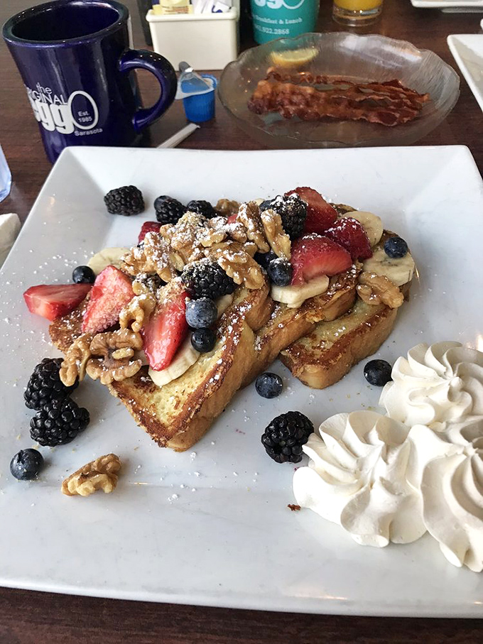 French toast that looks like it graduated from finishing school with honors in deliciousness and berry arrangement.