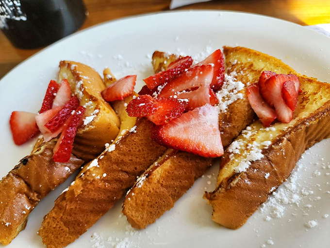 French toast that actually remembers it's supposed to be custardy inside. Those strawberries aren't garnish&mdash;they're essential supporting actors.