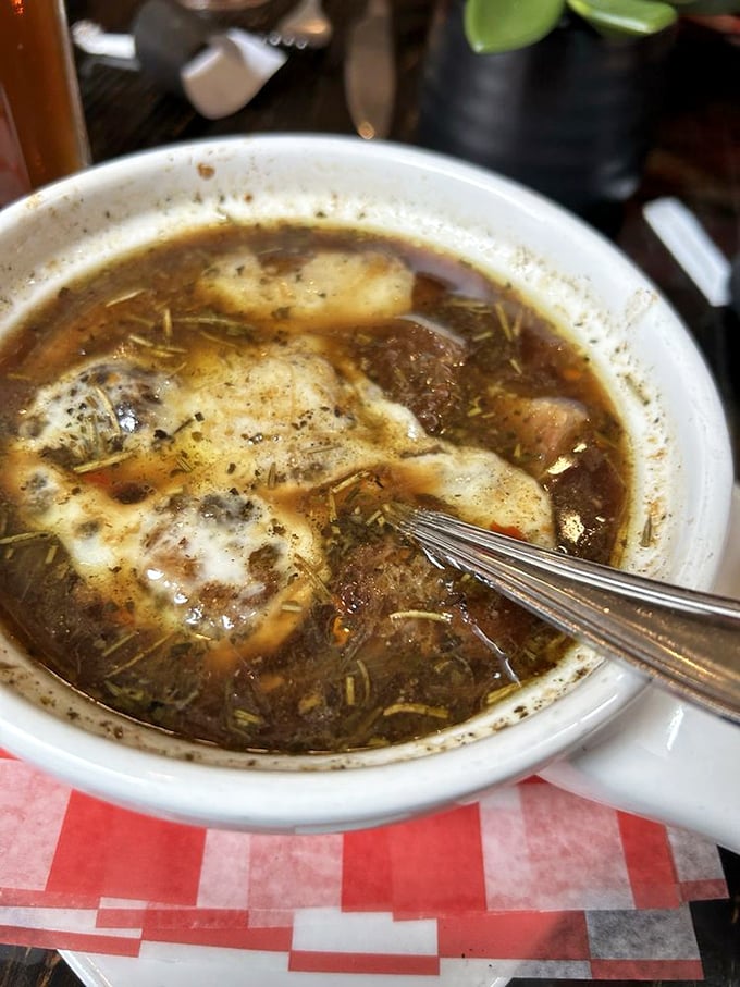 French onion soup so rich it should have its own tax bracket, with a gooey cheese roof that demands to be broken into with reverent delight.
