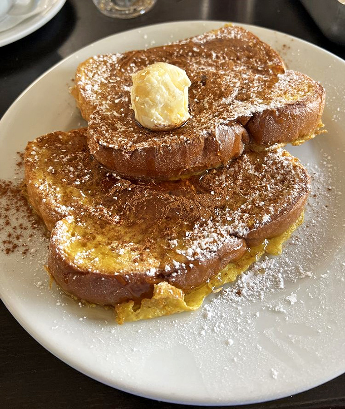 French toast that's achieved that magical caramelized exterior while maintaining its custardy soul. The powdered sugar is just showing off.