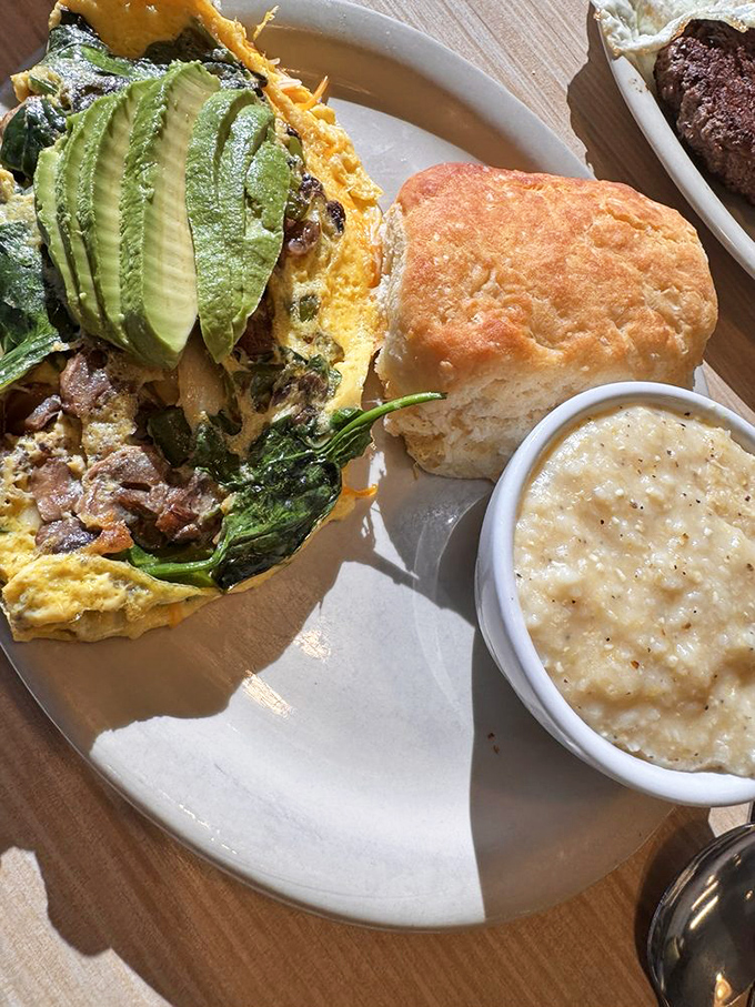 This garden omelette stuffed with fresh veggies alongside a golden biscuit proves breakfast is the most important art form of the day.