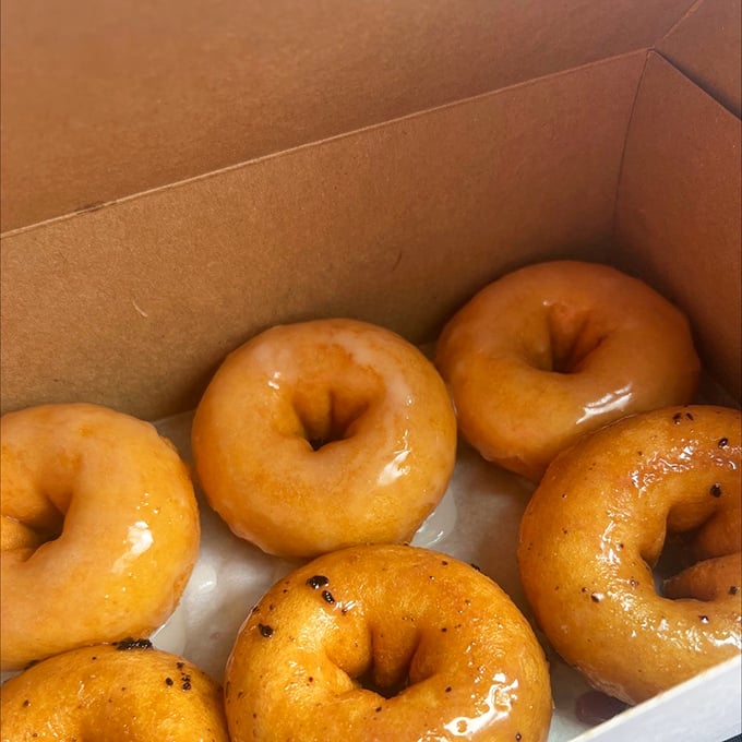 Classic glazed donuts in their natural habitat&mdash;a box that serves as both transportation and temporary holding cell.