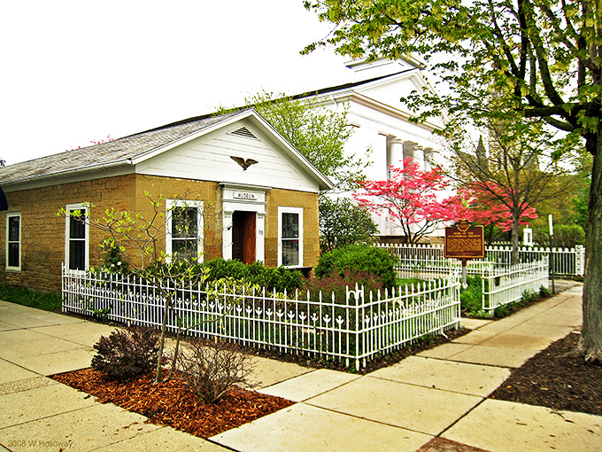 This charming historic building with its white picket fence looks like it was plucked straight from a Norman Rockwell painting.