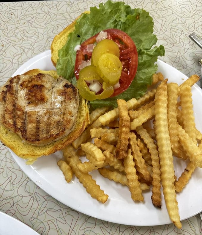 A perfectly grilled chicken sandwich with crispy crinkle-cut fries. Sometimes the simplest pleasures are the most satisfying.